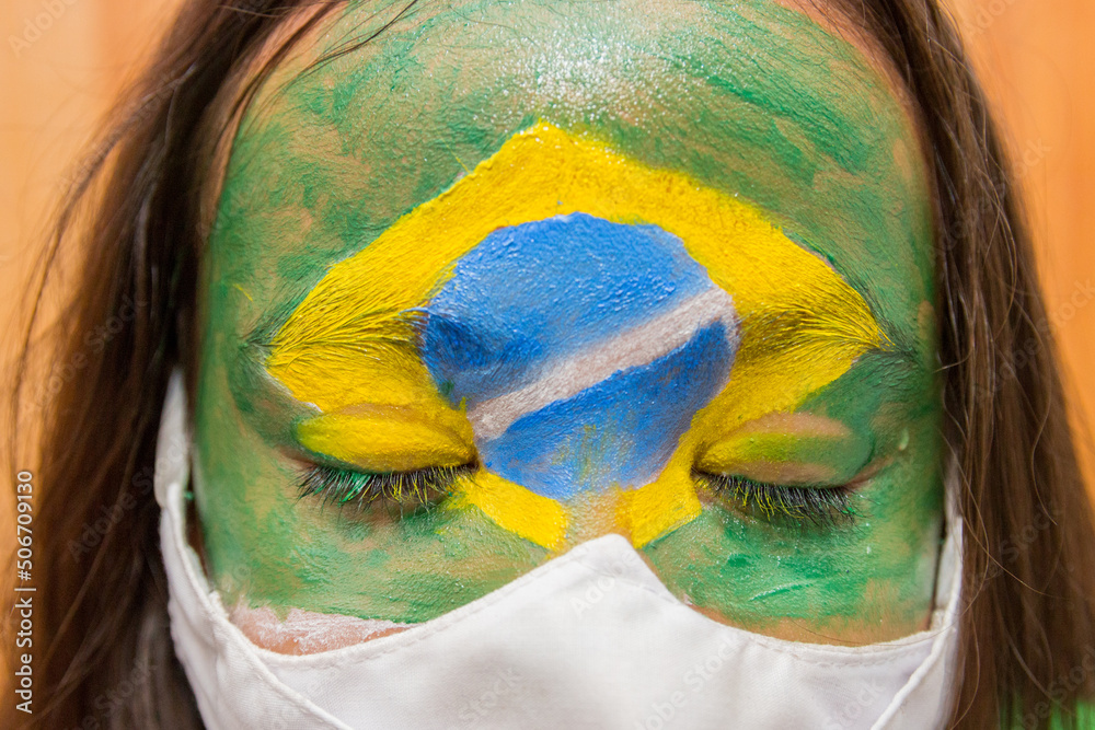 child with a mask with his face painted with the flag of Brazil, in Rio ...