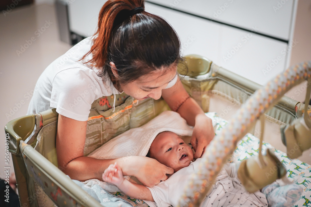 Mother and baby. Young Asian mother is take care her newborn baby while sleep. Moms Concept ...