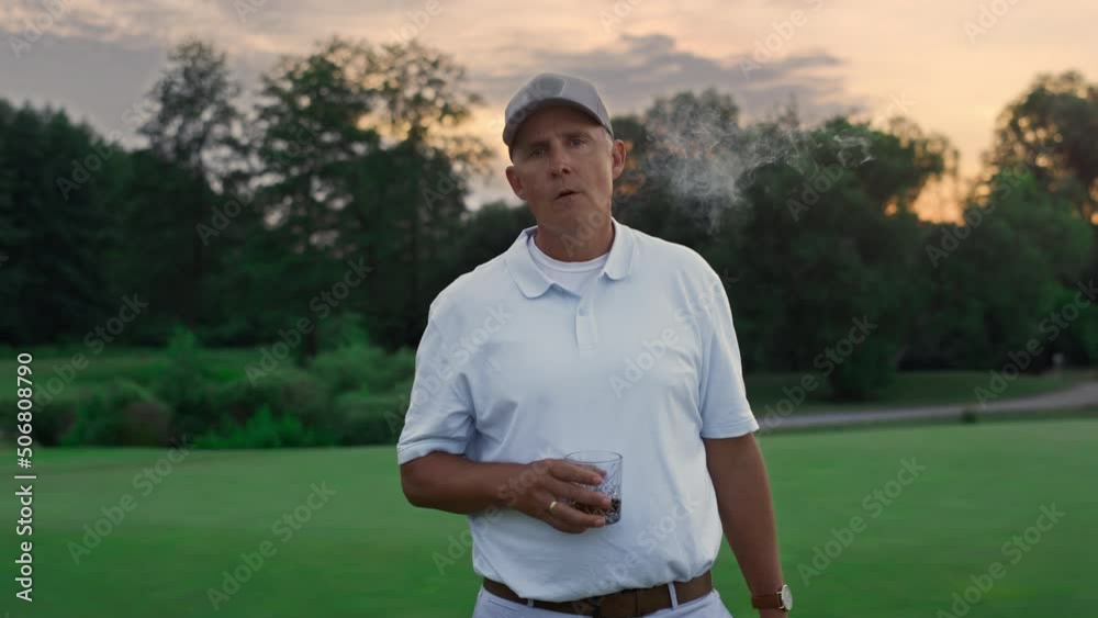 Rich golf player stand relaxed on course. Old man smoking cigar holding ...