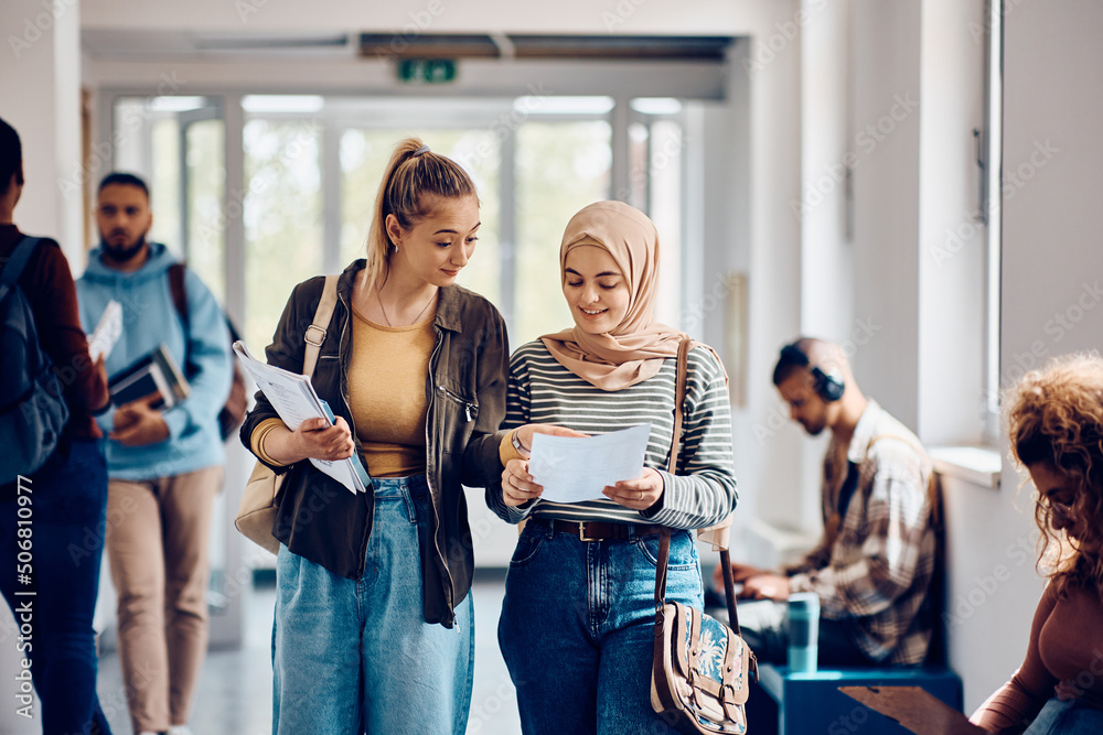 Happy Muslim student and her friend read their exam results while ...