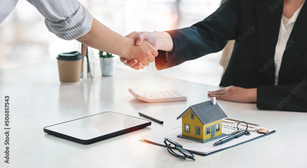 Real estate agent or realtor handshake with her client after the deal ...