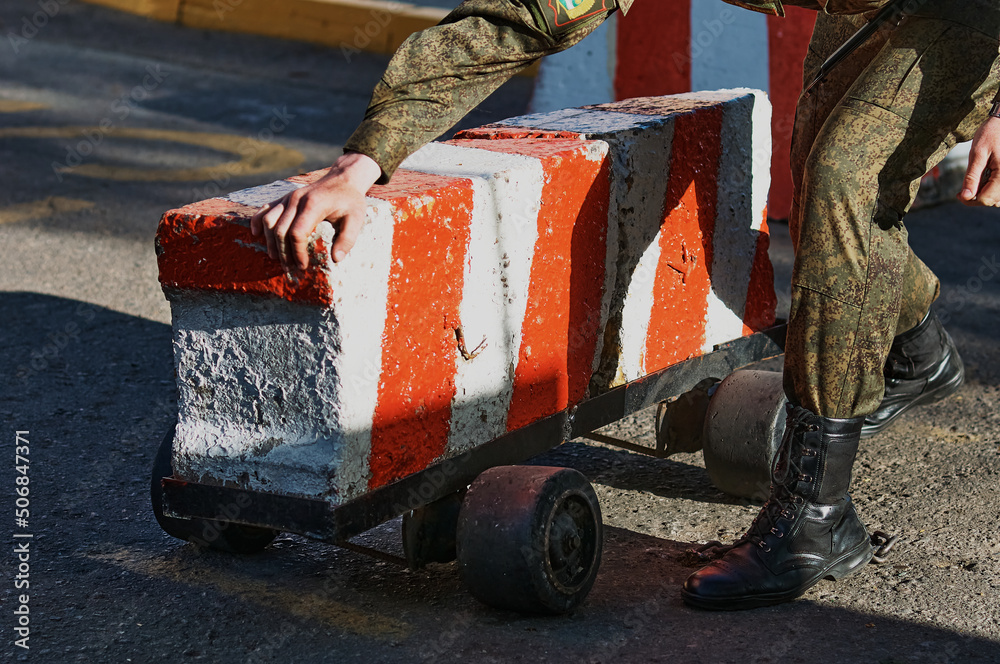 Road checkpoint. A soldier moves a concrete barrier. Control of the ...