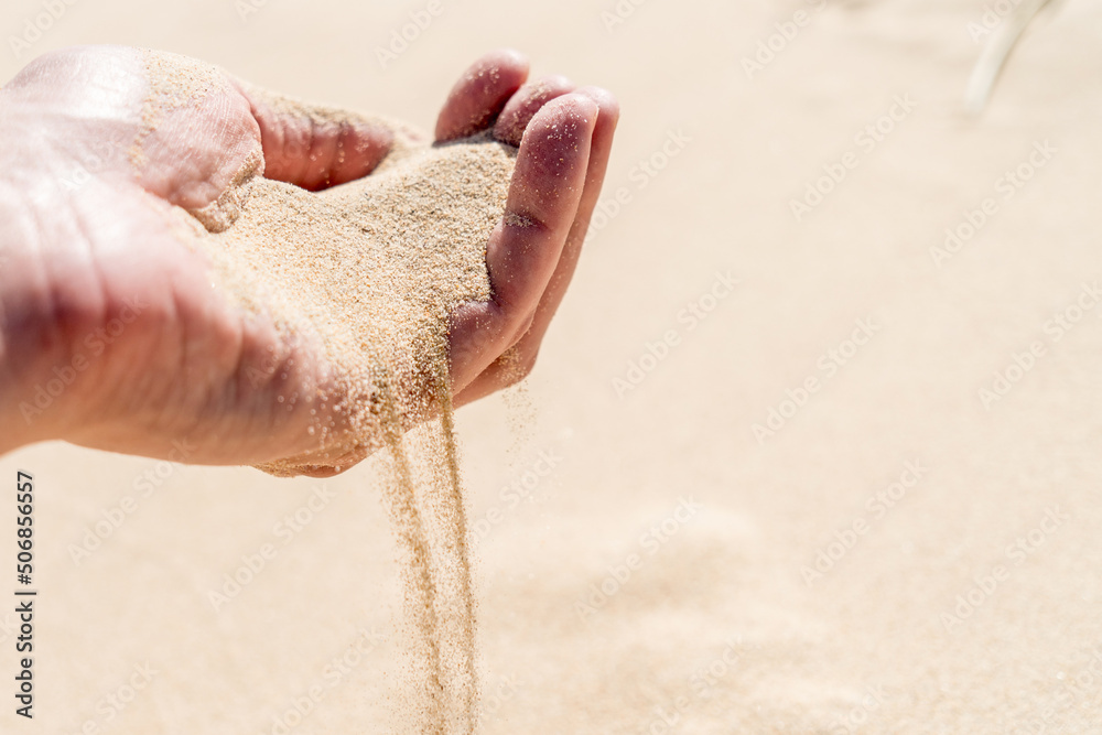 Sand spilling out pouring flow of the hand in the sandy desert dunes on ...