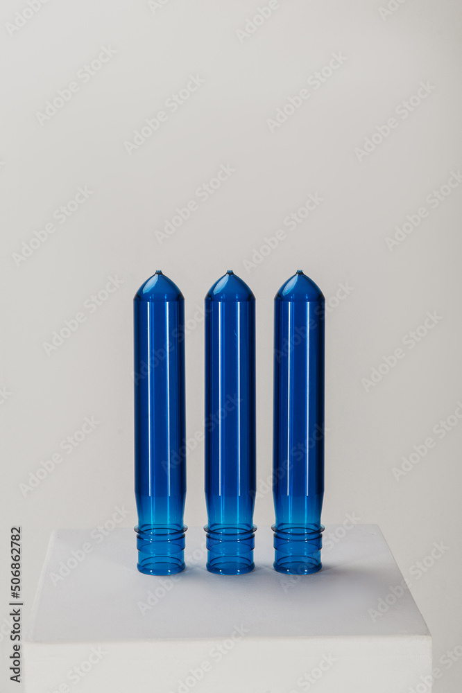 Preforms for PET bottles and kegs before the blow molding, filling and labeling process. blue ...