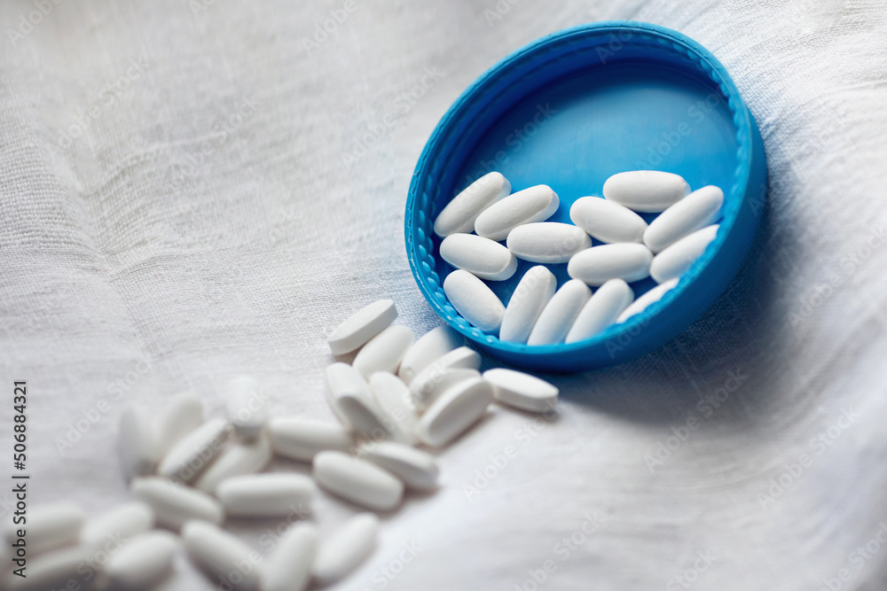 White pills close-up on a blue-white background. close-up ...