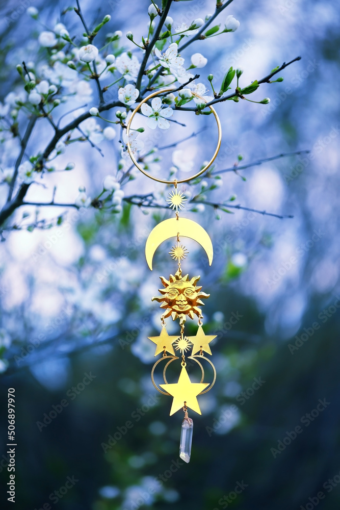 Solar golden amulet on blossoming branch, natural abstract spring ...