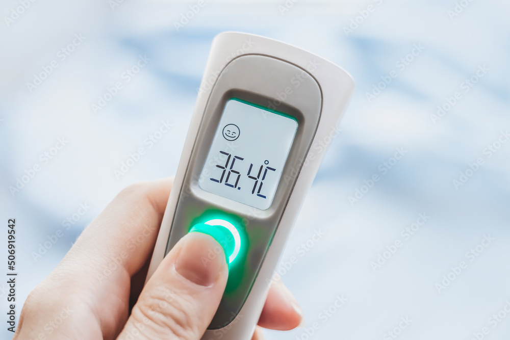 Hand holding ir thermometer with normal temperature. close up. Infrared ...
