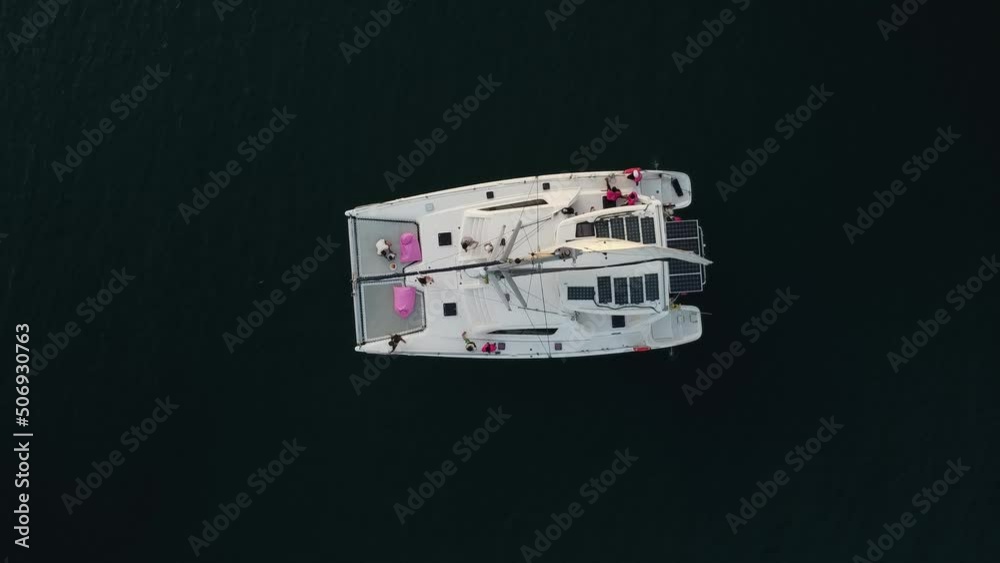 Sailing catamaran with a raised sail with tourists on board, top view ...