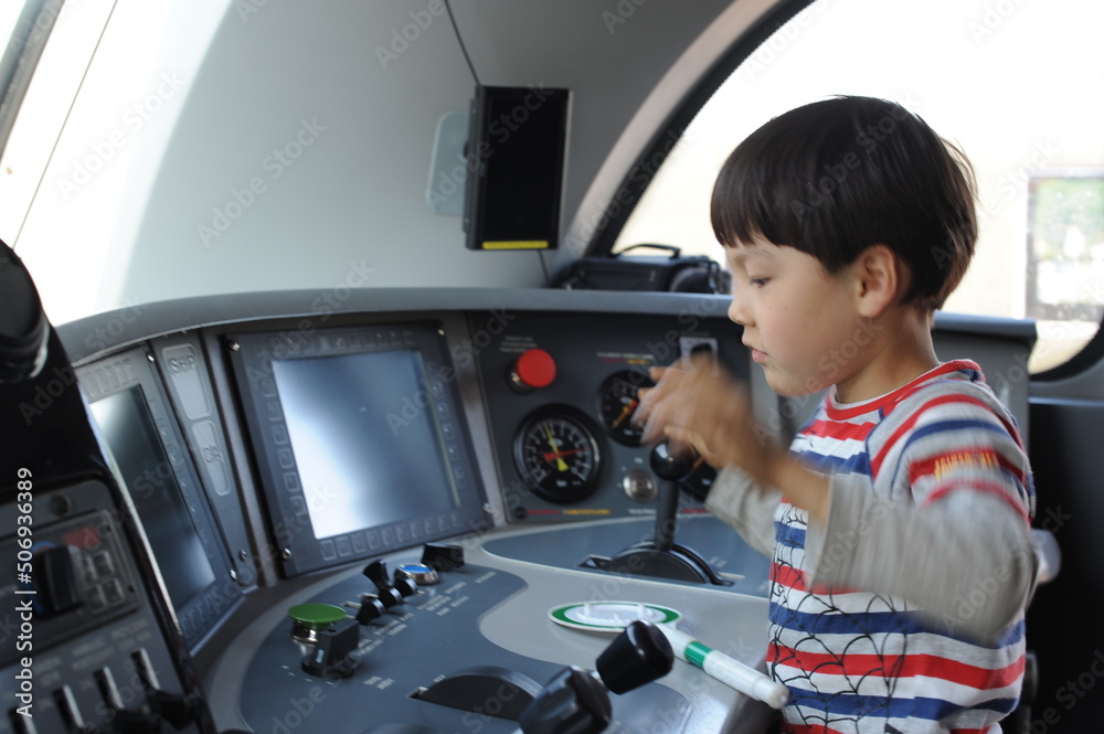 Foto Stock A young boy steering a locomotive and train in a driving ...