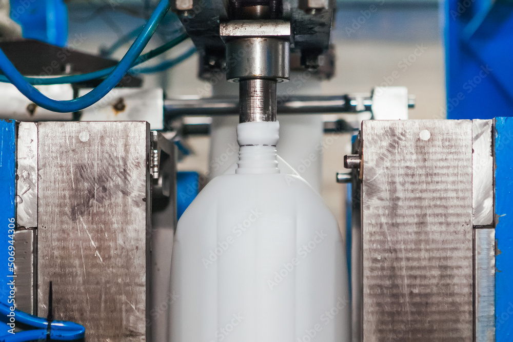 Production of plastic canisters on an automatic conveyor. The mechanism ...