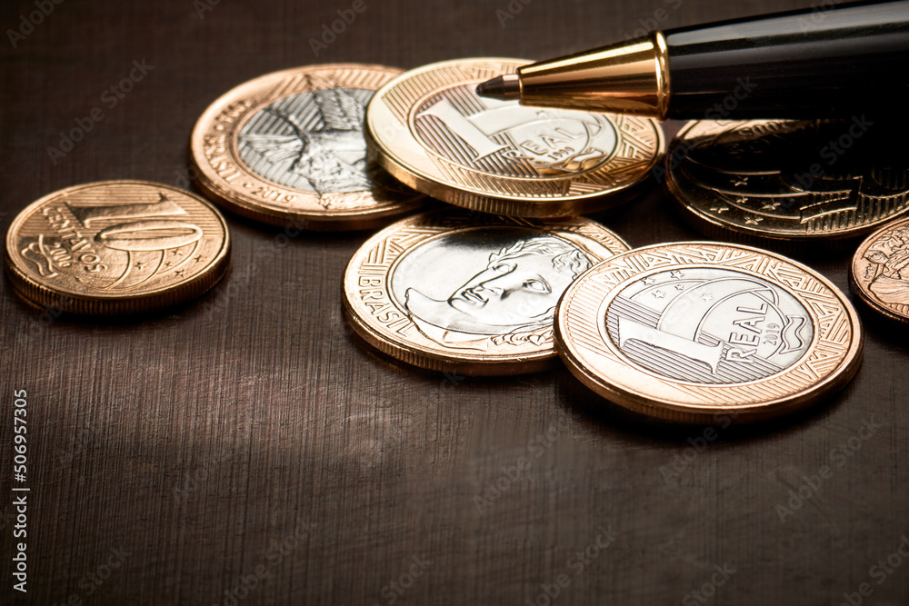 Moedas de Real brasileiro em close up, num fundo de madeira escura com ...