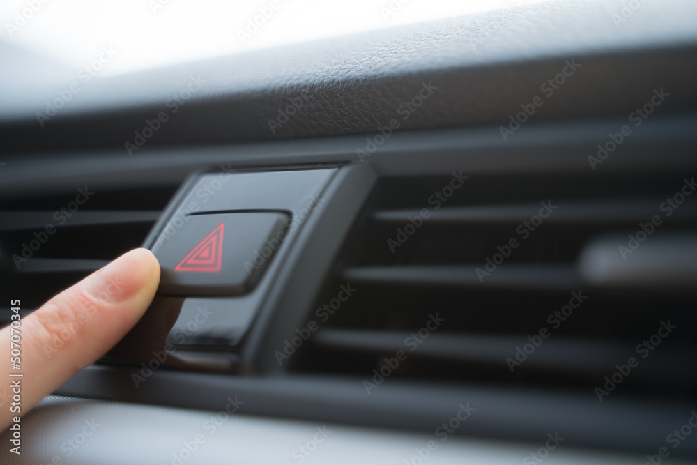 Close-up - the person presses the emergency stop button in the car ...