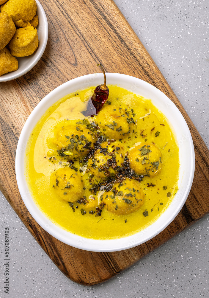 Kadhi Pakora, a Punjabi cuisine made with fritters dipped in curd based ...