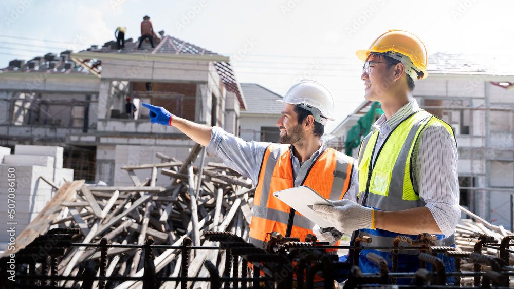 Team of two handsome engineers working together at a construction site ...