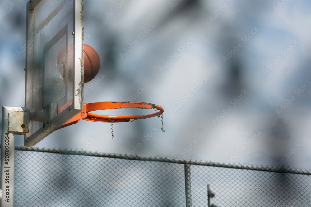 Basketball heading towards the hoop on an outdoor basketball court ...