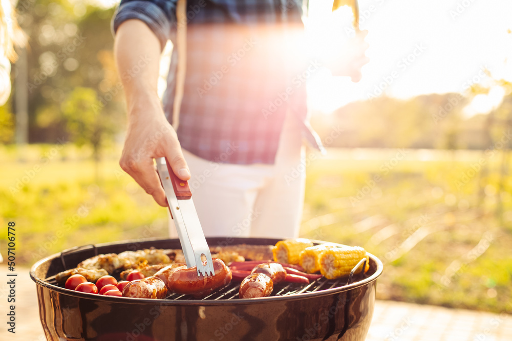 man prepares a barbecue for friends, happy friends make a barbecue ...