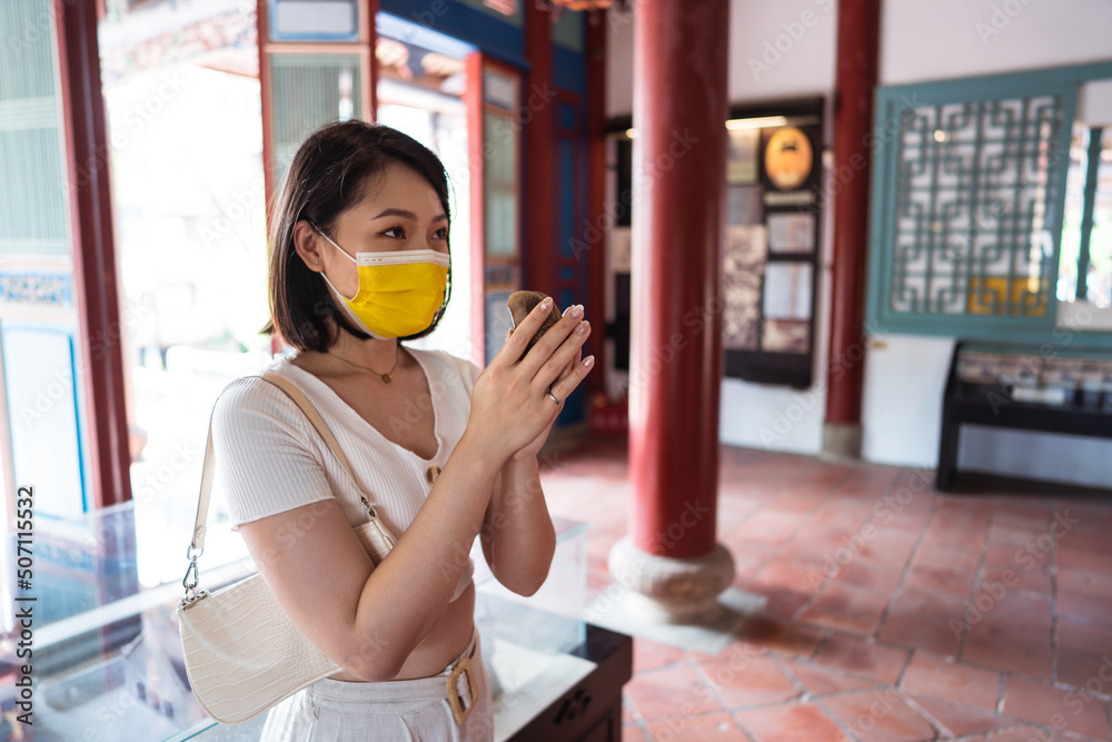 Calm young ethnic lady with jiaobei in hands standing in temple Stock ...