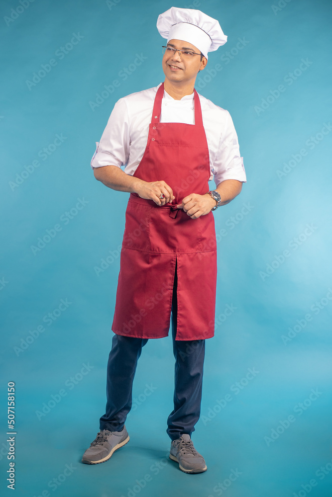 Successful cook. Male chef full length. Young cook on turquoise. Cafe ...