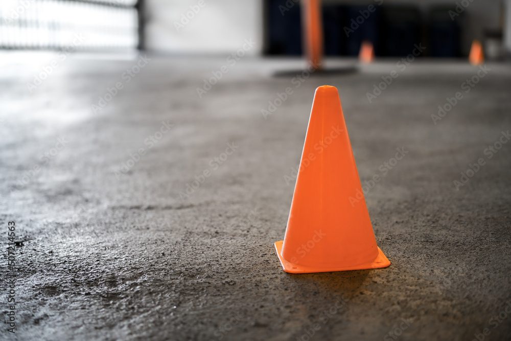 Safety cone on driveway in parking garage while repair work is in ...