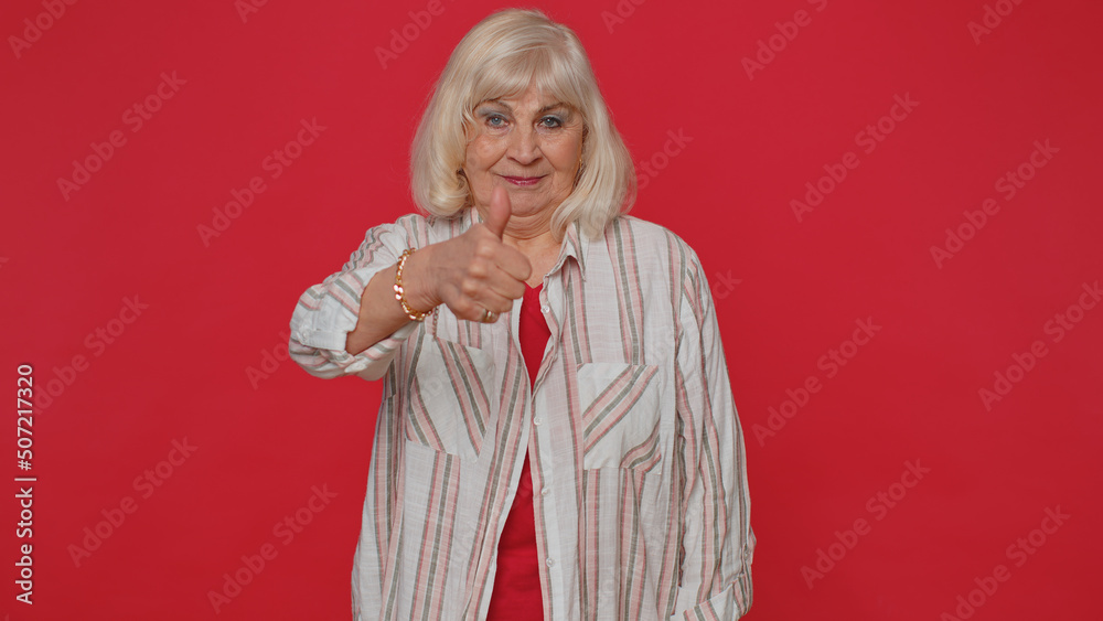 Elderly mature woman in casual shirt raises thumbs up agrees with ...