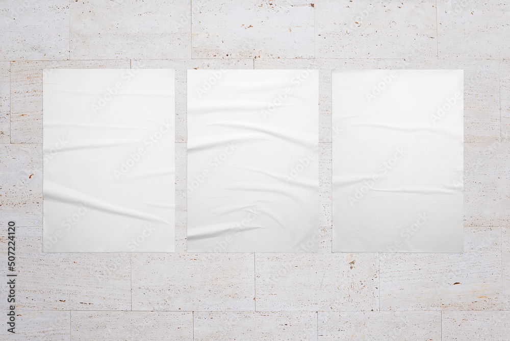 Three white posters on the interior wall. White blank crumpled texture ...