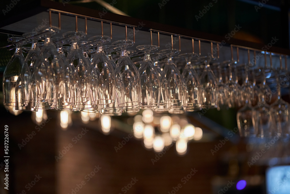 glasses hang over the bar in the restaurant. champagne glasses hanging ...