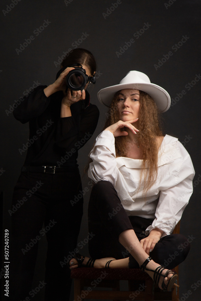 The model sits on a chair and the photographer makes a frame, a classic ...