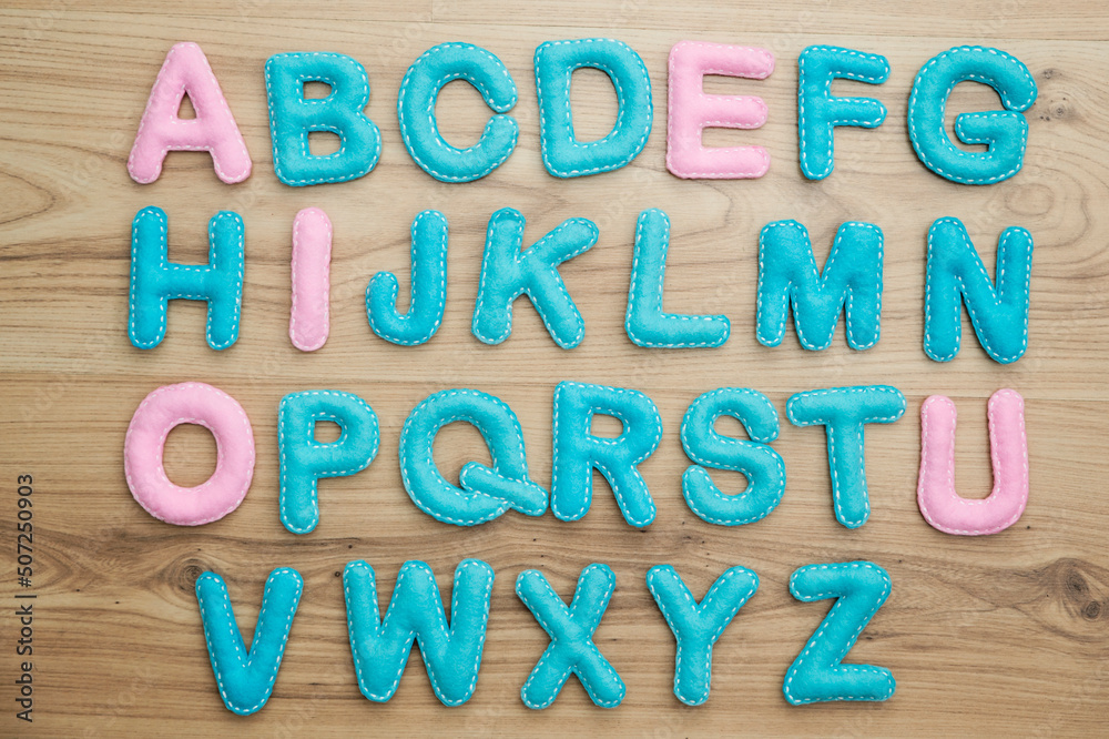 Full Alphabet In Capital Letters Made From Stuffed Felt On Wooden Floor Full Alphabet In Capital Letters Made From Stuffed Felt On Wooden Floor