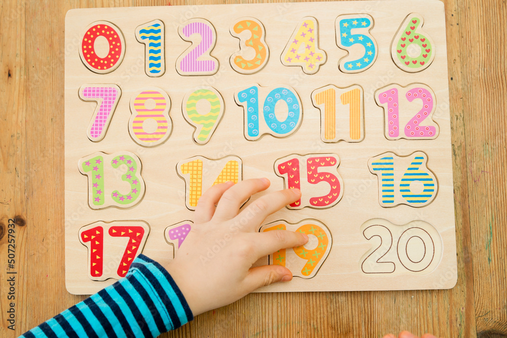 Kid learning numbers through game. Activity with wooden numbers ...
