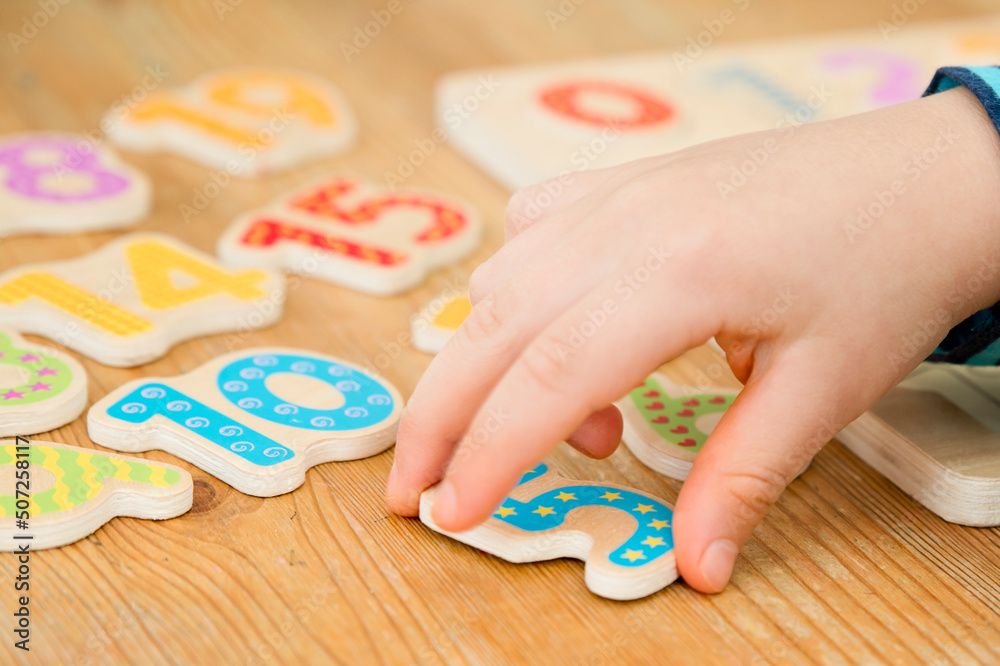 Kid learning numbers through game. Activity with wooden numbers ...