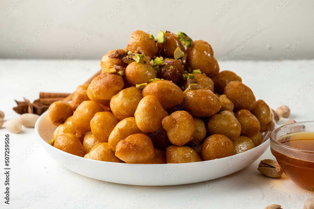 luqaimat or lokma sweet arabic fried dough dessert with sweet syrup in ...