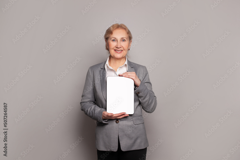 Happy middle aged senior lady holding digital tablet with empty display ...