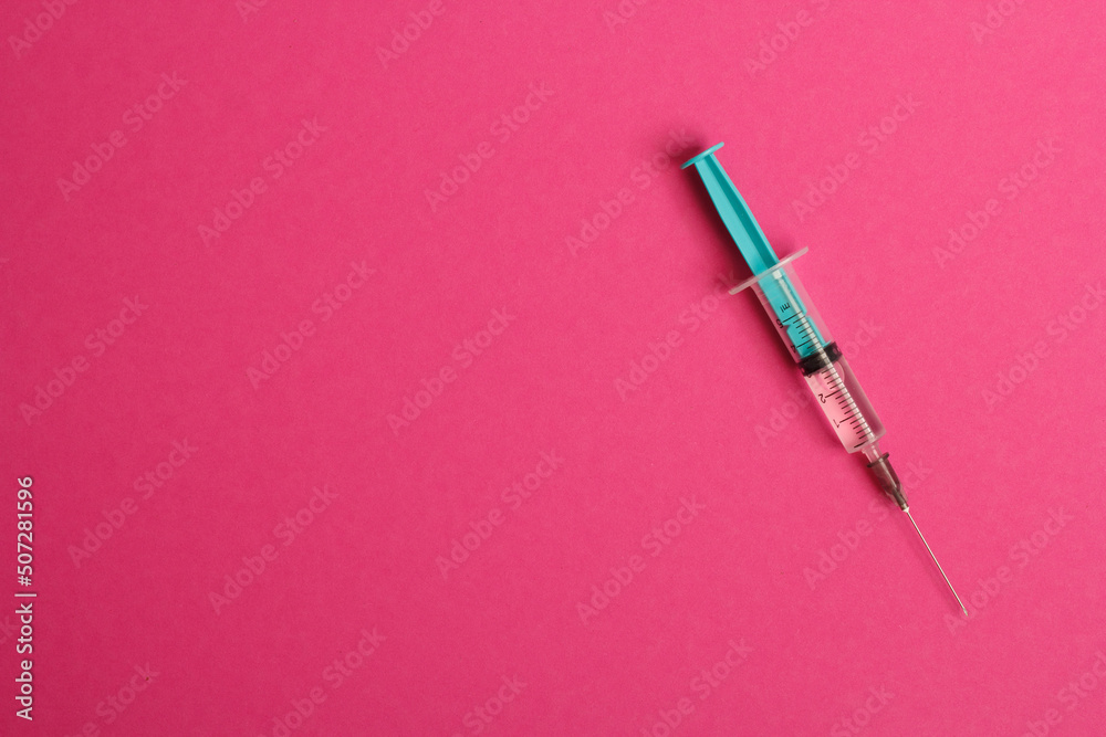 Medical syringe on a pink background. A syringe for injection. The ...
