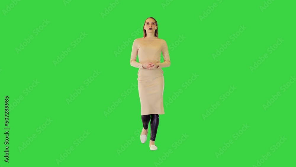 Robotic girl in beige dress walks making a slight nod on a Green Screen ...