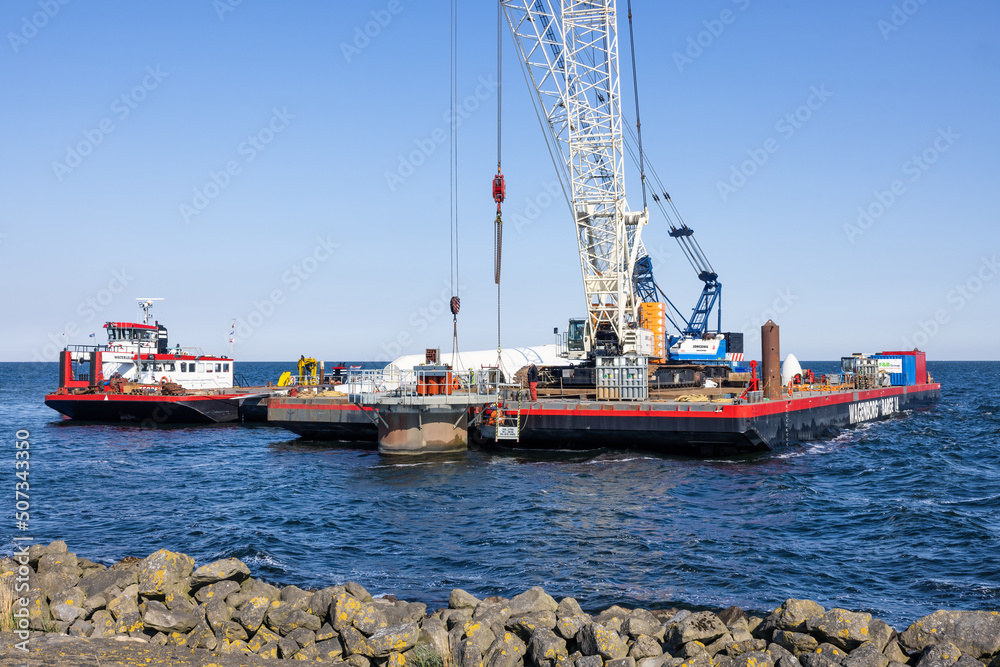 Crane ship and supply vessel busy with demolition offshore windturbine ...