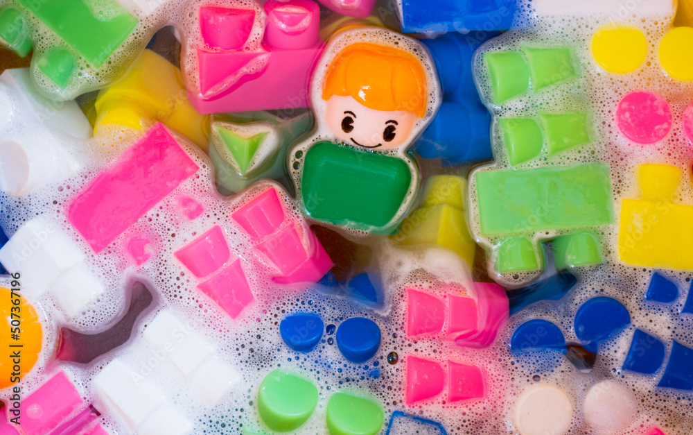 Washing of children toys, plastic building blocks with figurines. A ...