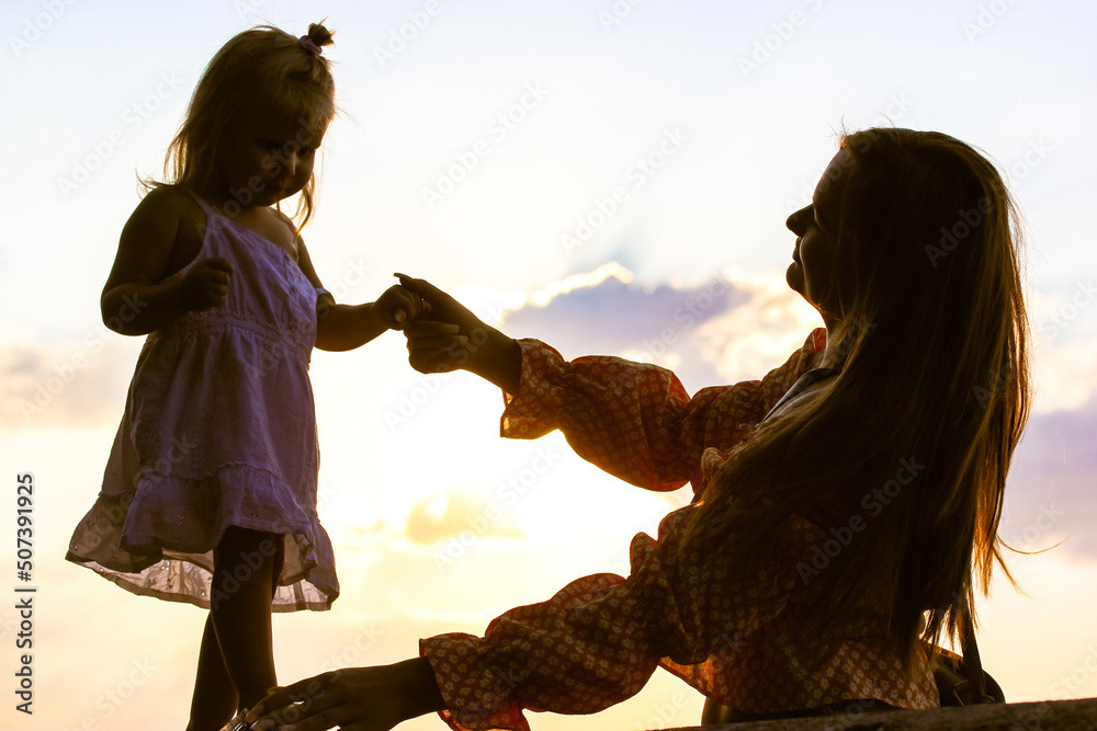 Silhouettes of young happy mother with little girl, cute toddler ...