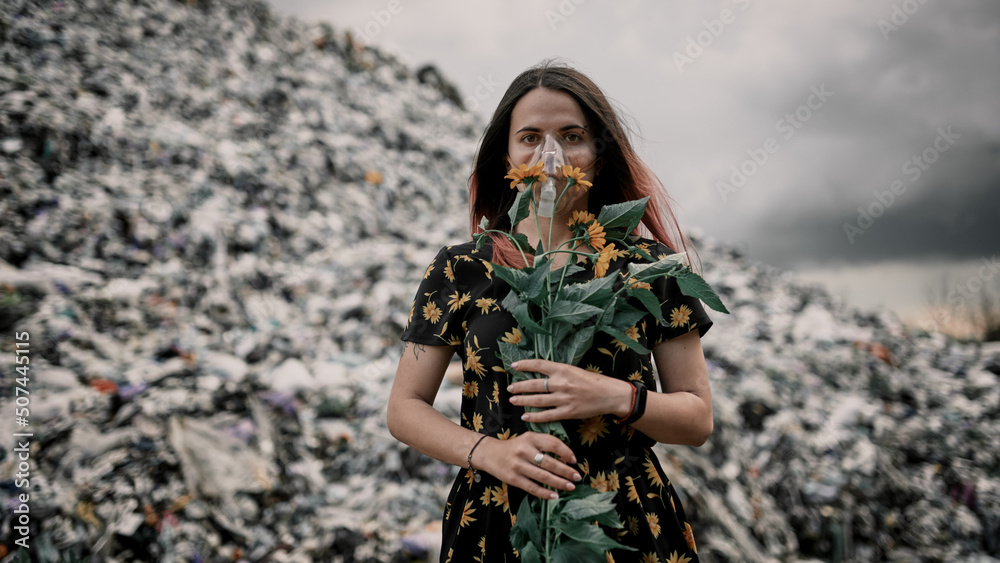 Girl in a garbage dump with flowers and in an oxygen mask ...
