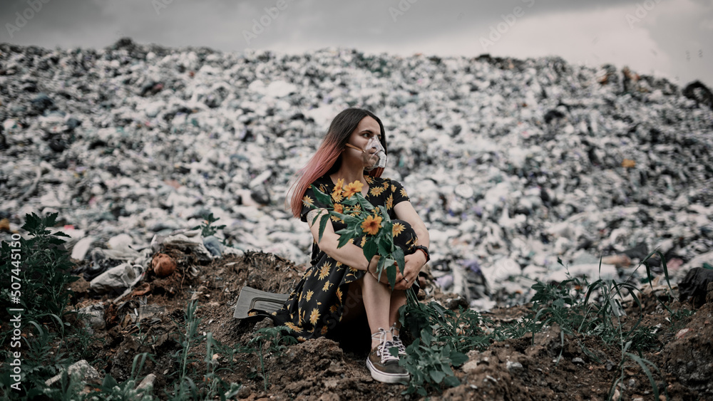 Girl in a garbage dump with flowers and in an oxygen mask ...