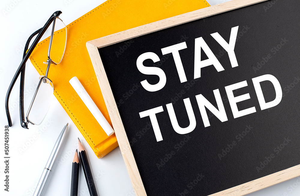 STAY TUNED text on the blackboard with notepad , pen, pencil Stock ...