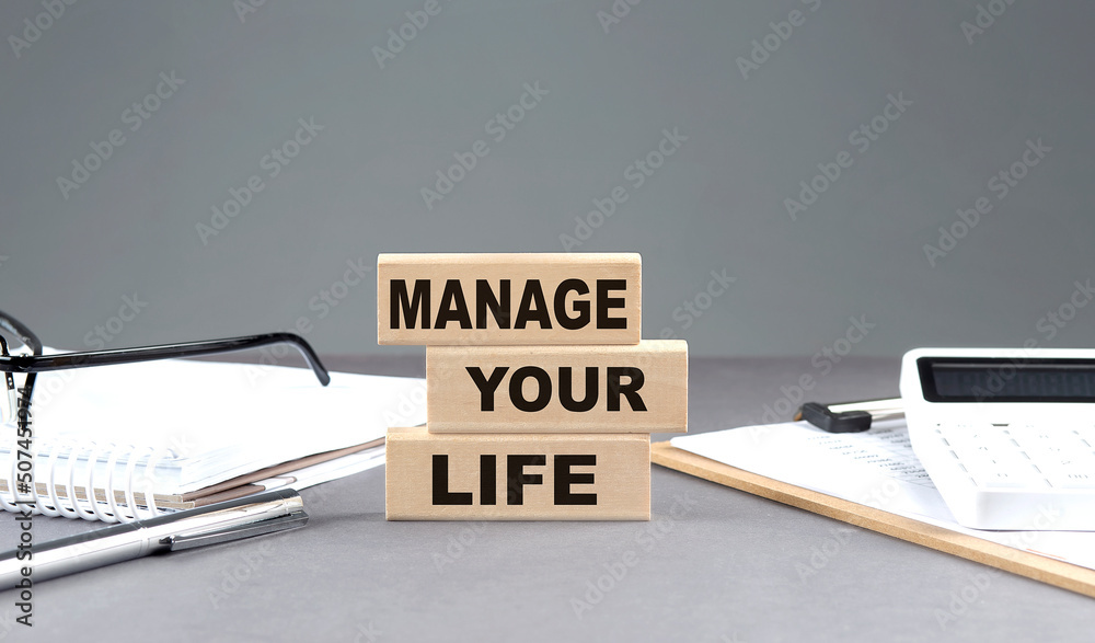 MANAGE YOUR LIFE text on wooden block with notebook,chart and ...