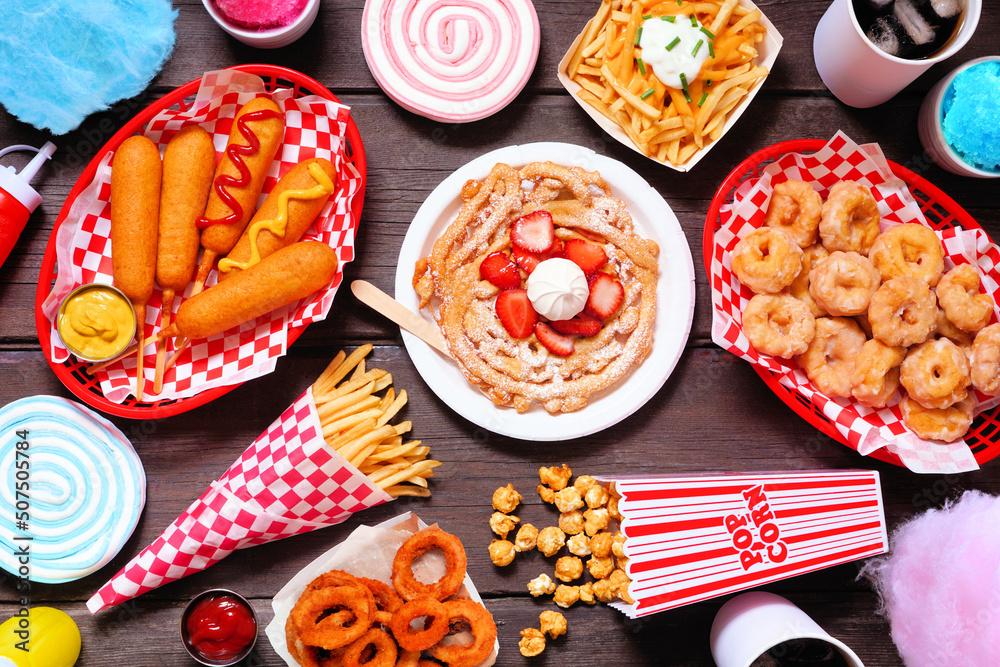 Carnival theme food double border over a dark wood background. Above ...