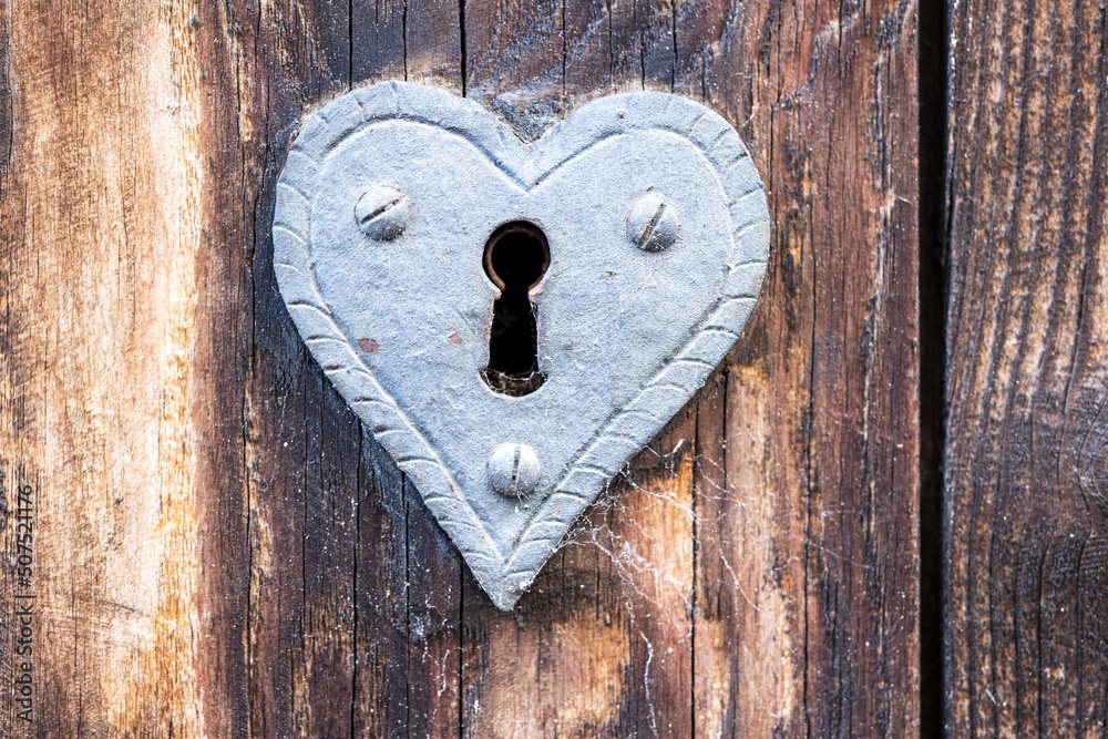 Historical door lock in the shape of a heart on a medieval wooden door ...