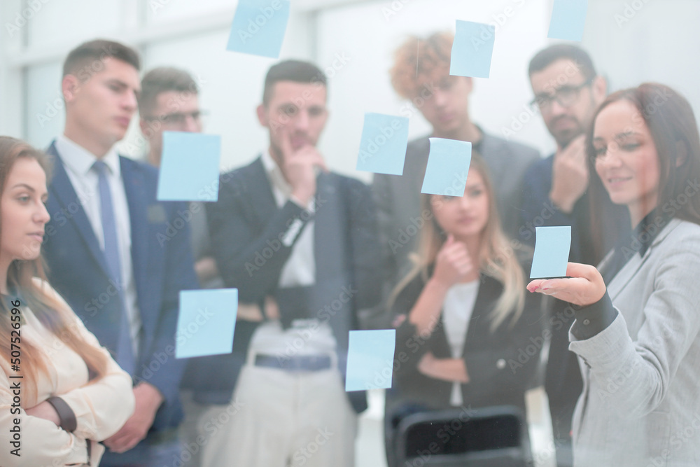 employees discussing sticky notes on the glass Stock Photo | Adobe Stock