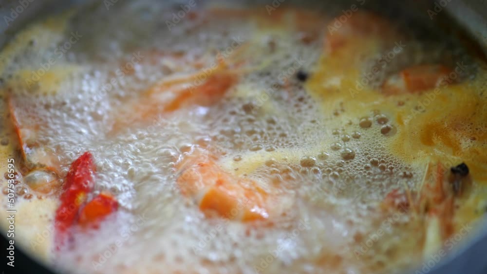 Top view video 4k of spicy prawn soup or Tom Yum Kung In a boiling pot ...