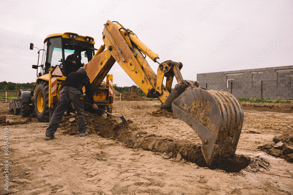 Excavator working at house construction site - digging foundations for ...