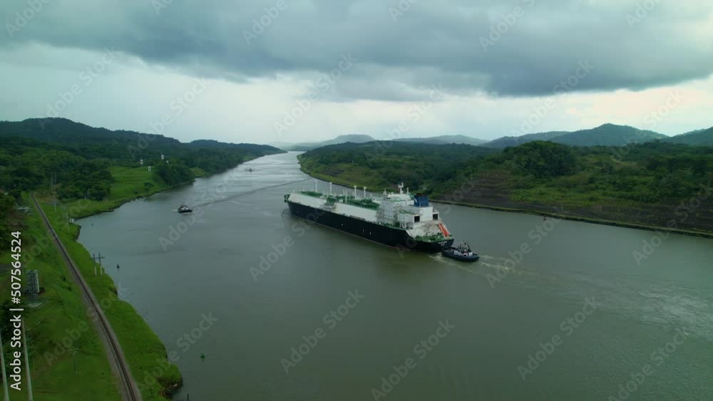 AERIAL: Massive freight ship is assisted along the breathtaking Panama ...