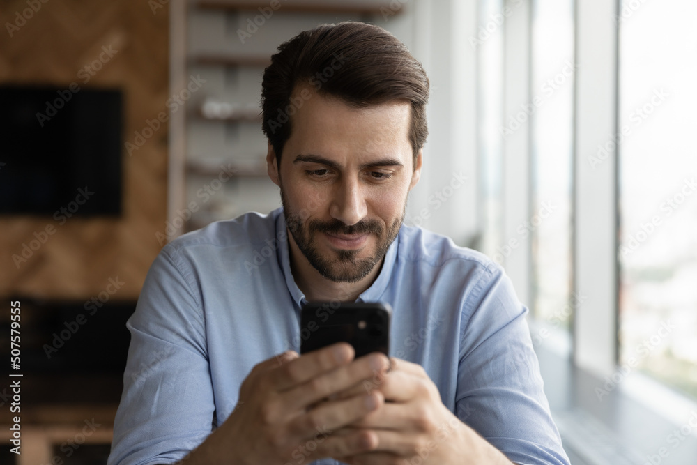 Happy millennial man using app on smartphone, making telephone call ...