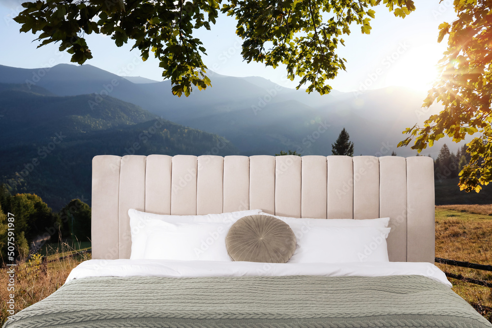 Comfortable bed with soft pillows and picturesque view of mountains on ...