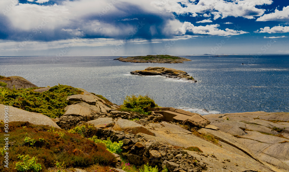 local rain showers over islets and reefs in a barren coastal landscape ...